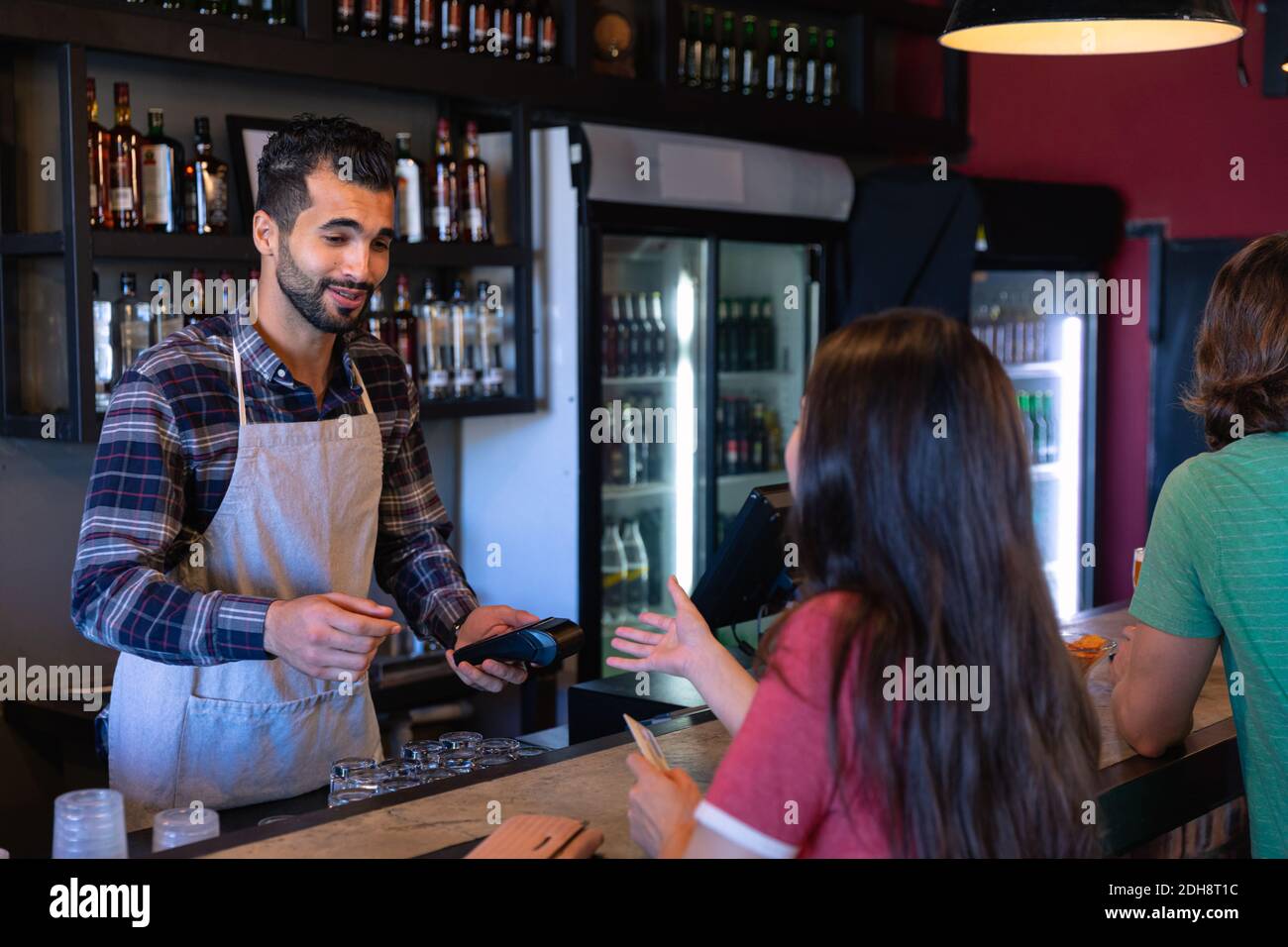 Caucasian woman paying at the counter with her card Stock Photo - Alamy