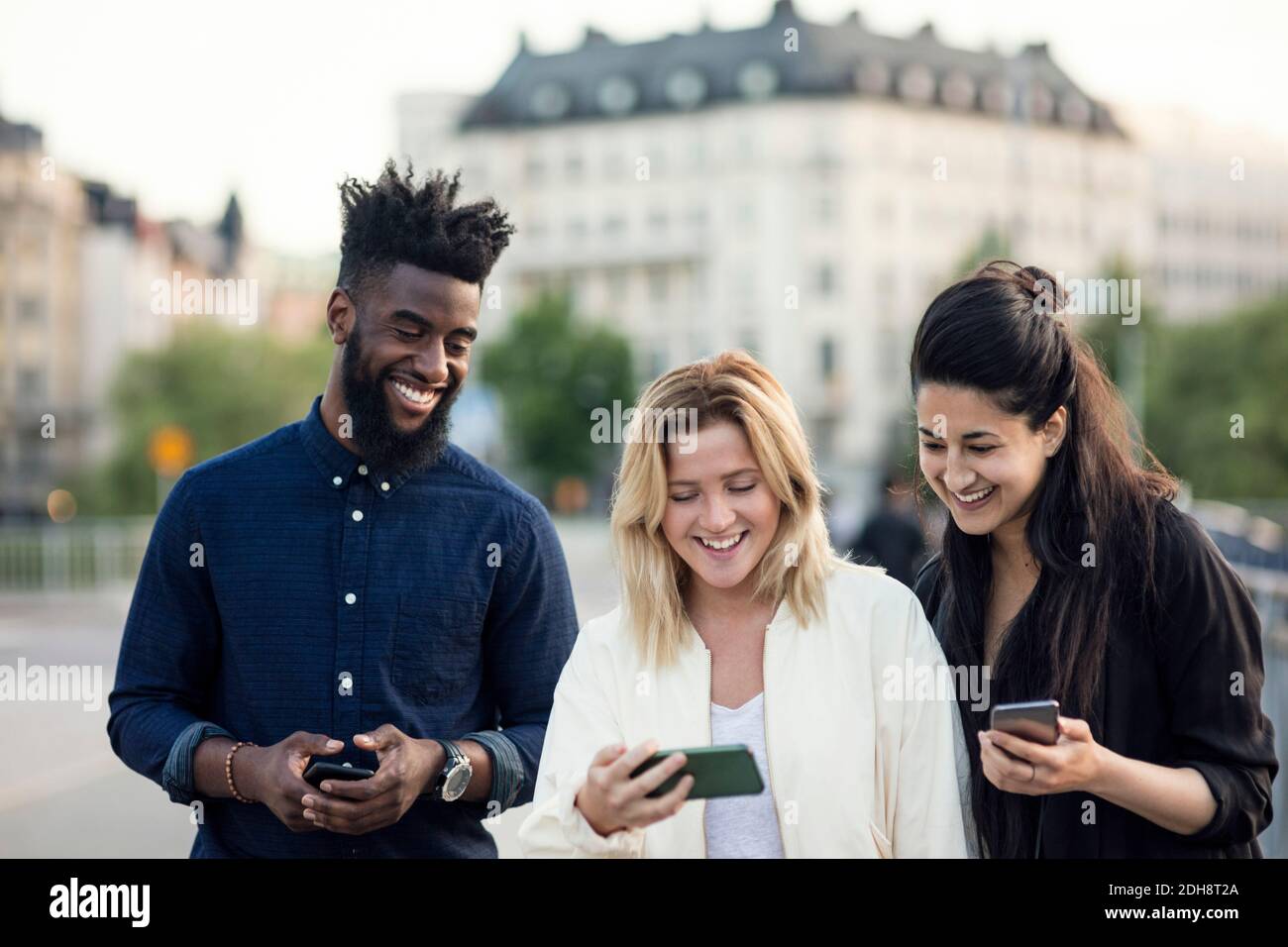 Happy friends looking mobile hi-res stock photography and images - Alamy