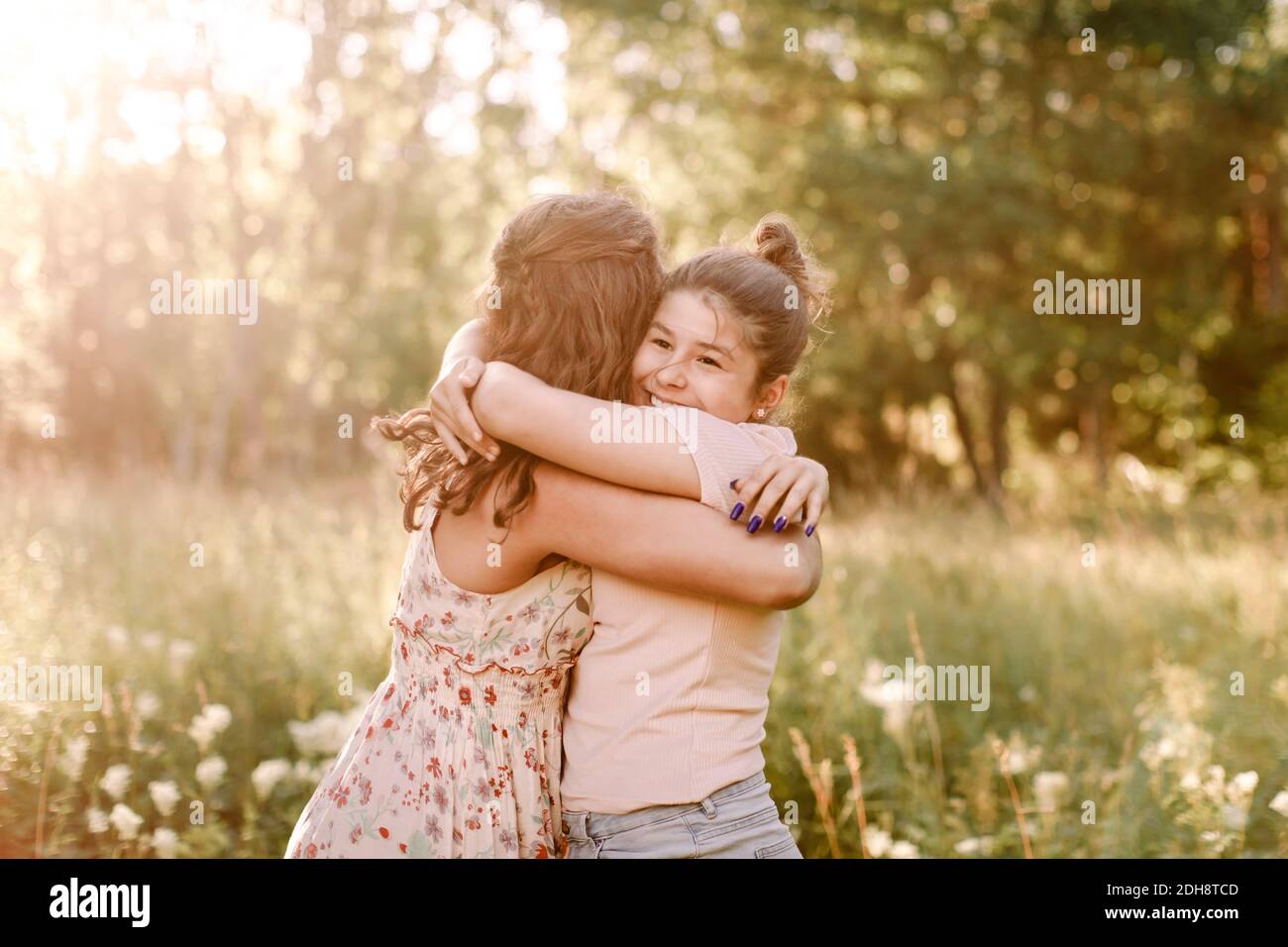 Happy siblings embracing each other in backyard Stock Photo - Alamy