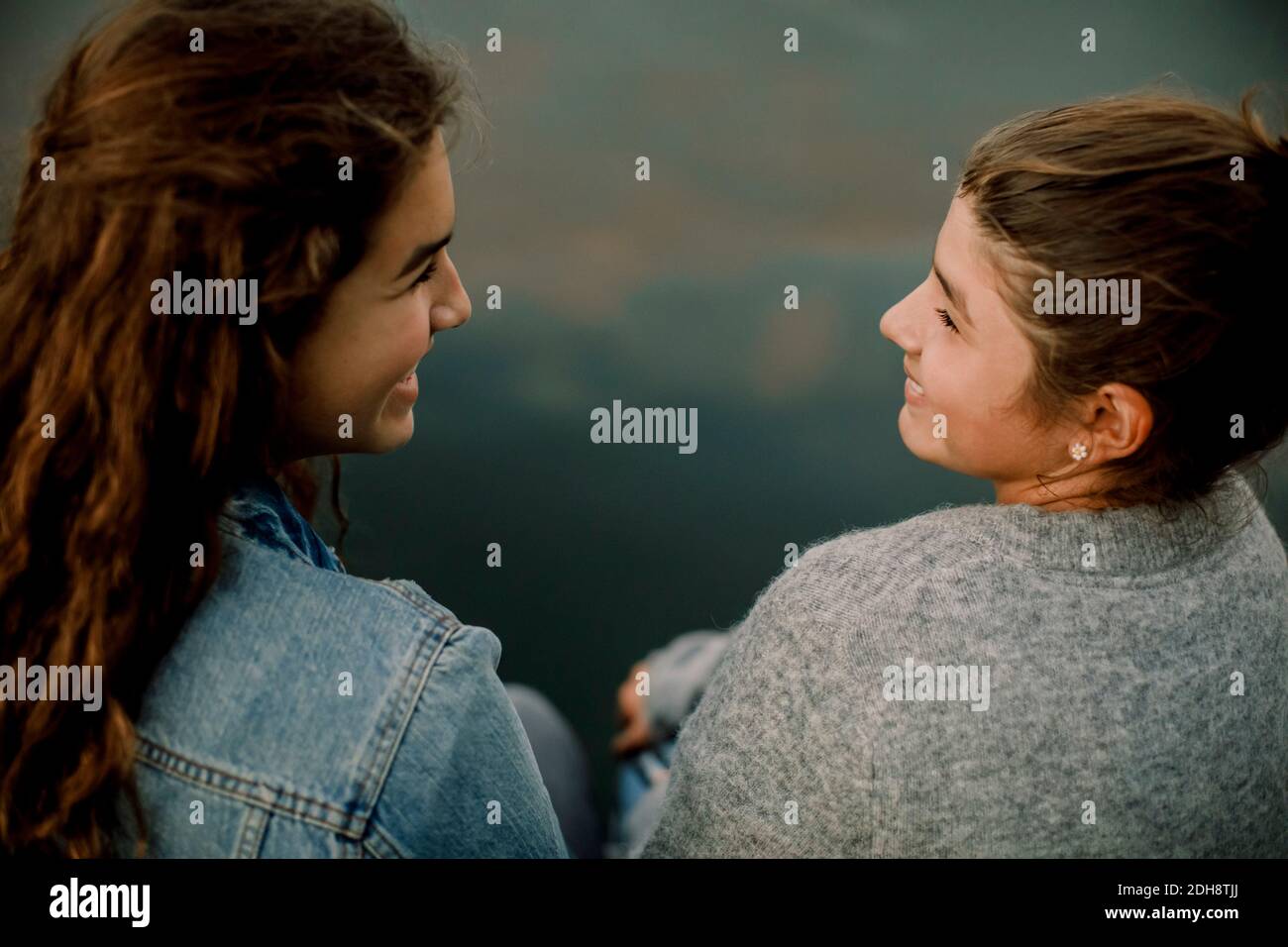 High angle view of smiling siblings talking against lake Stock Photo ...