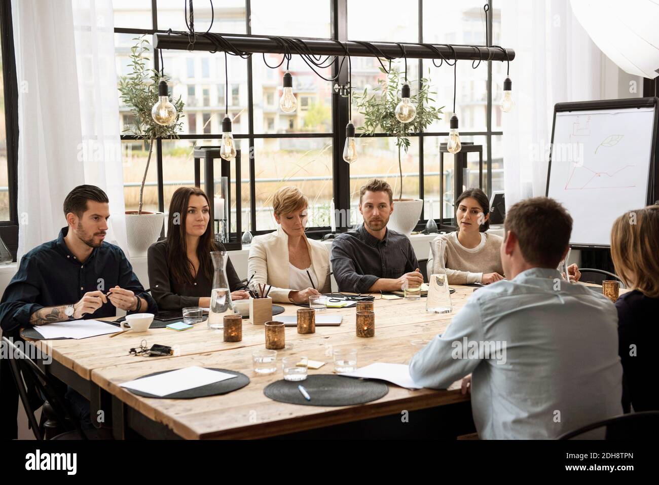 Business people taking interview against window in office Stock Photo ...