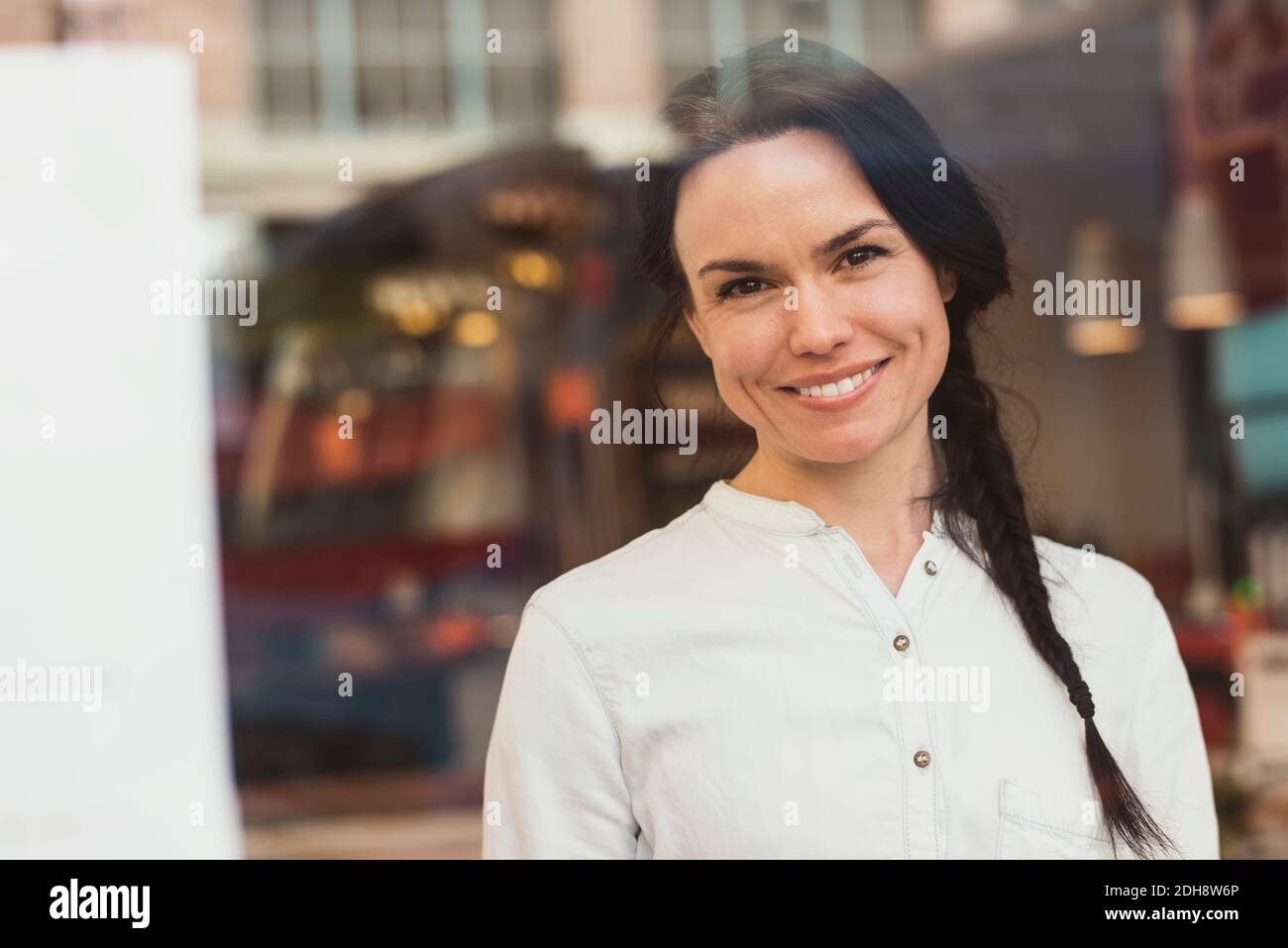 Portrait of smiling customer seen through glass window Stock Photo - Alamy