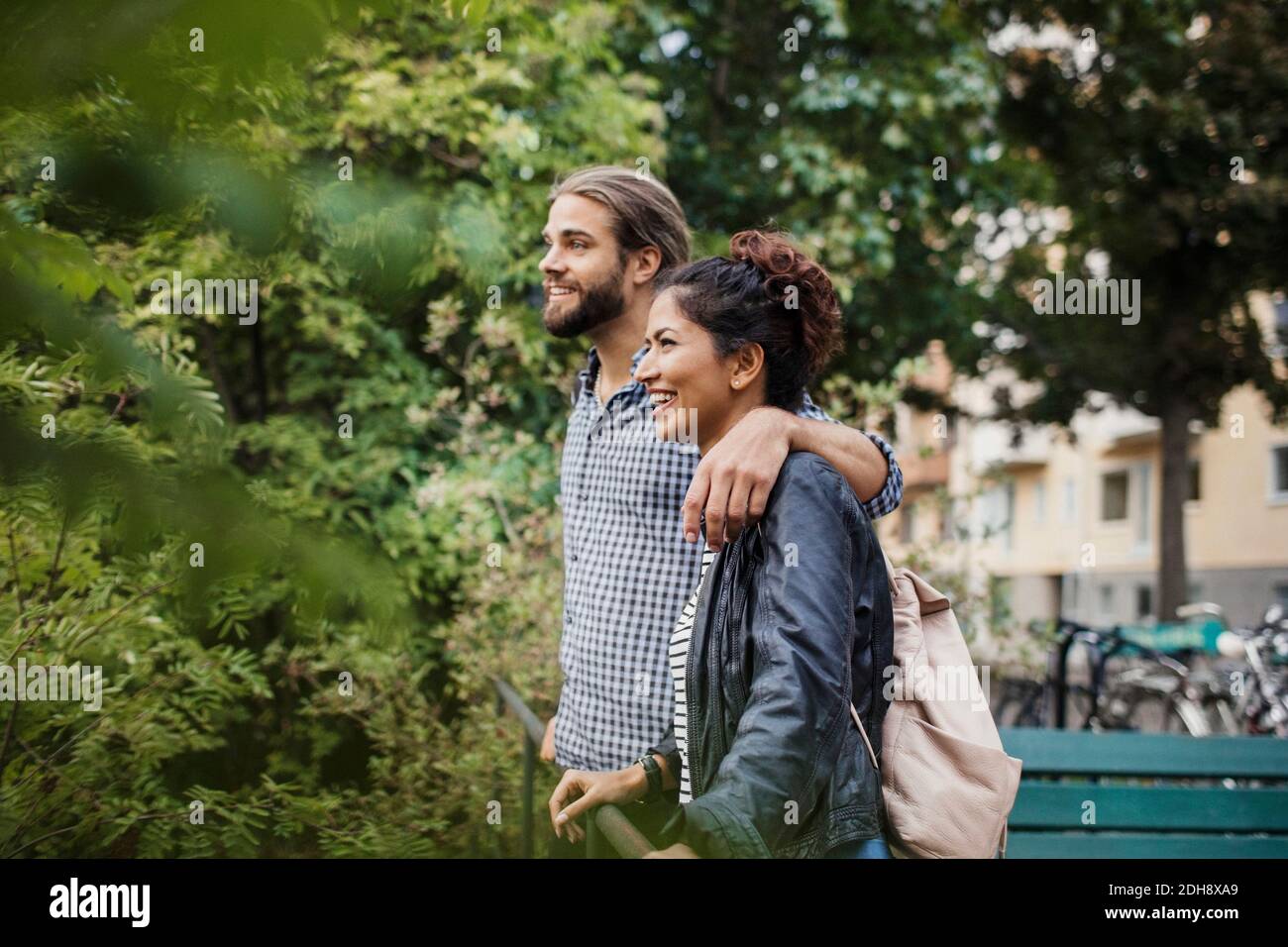 Side view of happy loving couple walking by trees at park Stock Photo ...