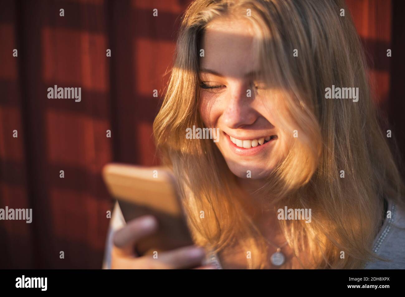 Close-up cheerful teenage girl using mobile phone Stock Photo - Alamy