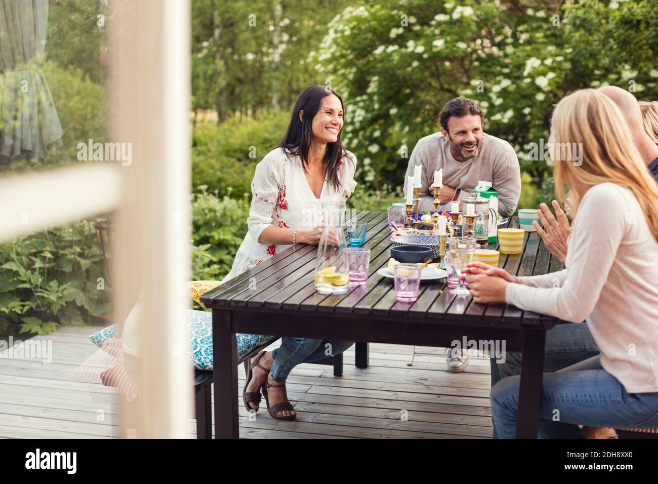 Happy family and friend sitting at dining table in back yard Stock ...