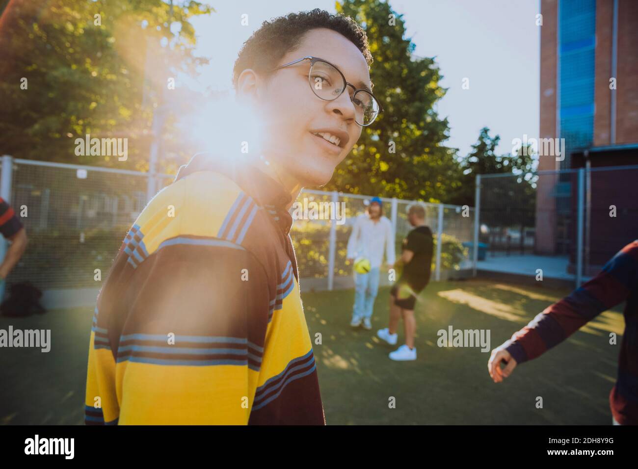Portrait of confident male with friends playing sports in field Stock ...