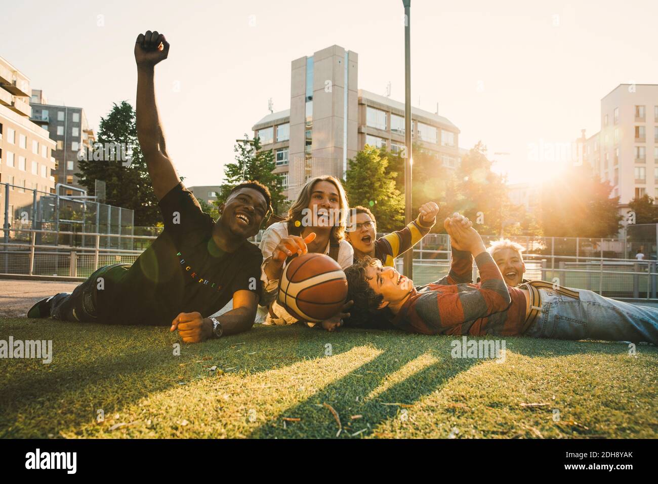 Happy friends cheering while lying in park Stock Photo - Alamy