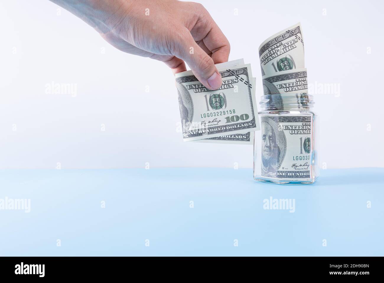 Hand putting money paper into jar isolated grey background. Property ...