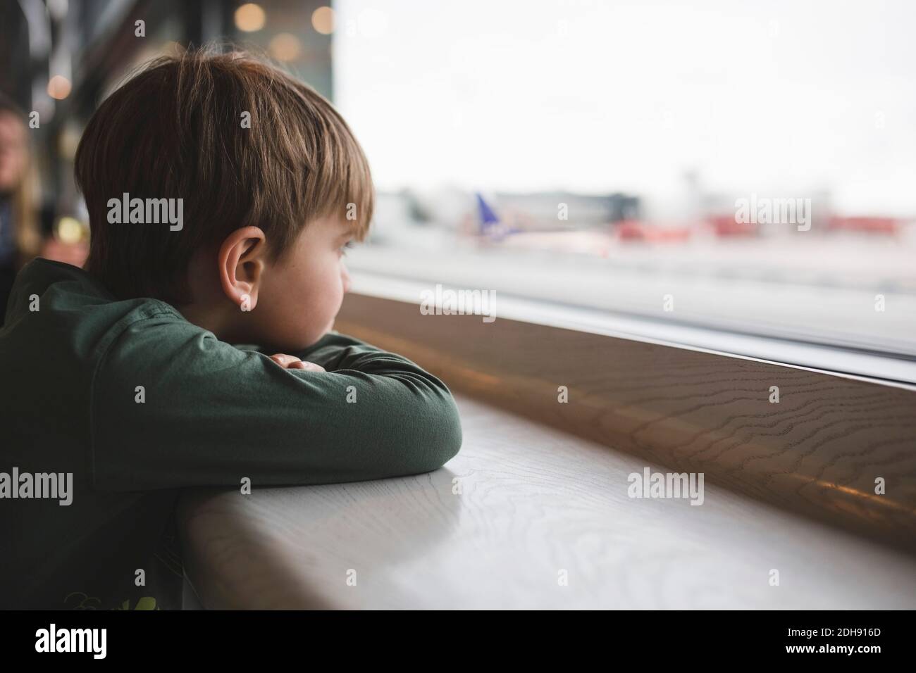 Boy looking through window of restaurant Stock Photo - Alamy