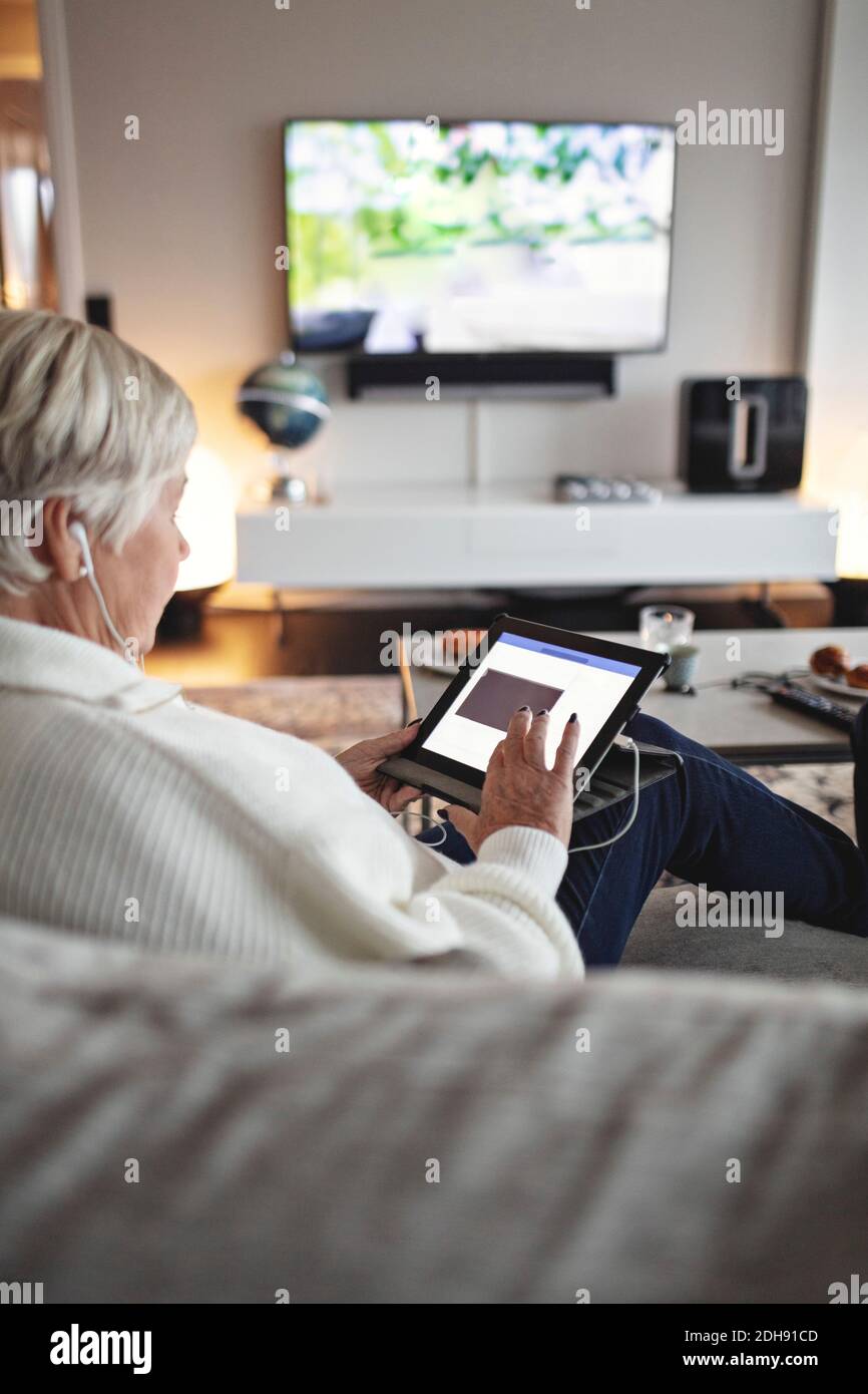 Woman uses tablet sitting table hi-res stock photography and images - Alamy