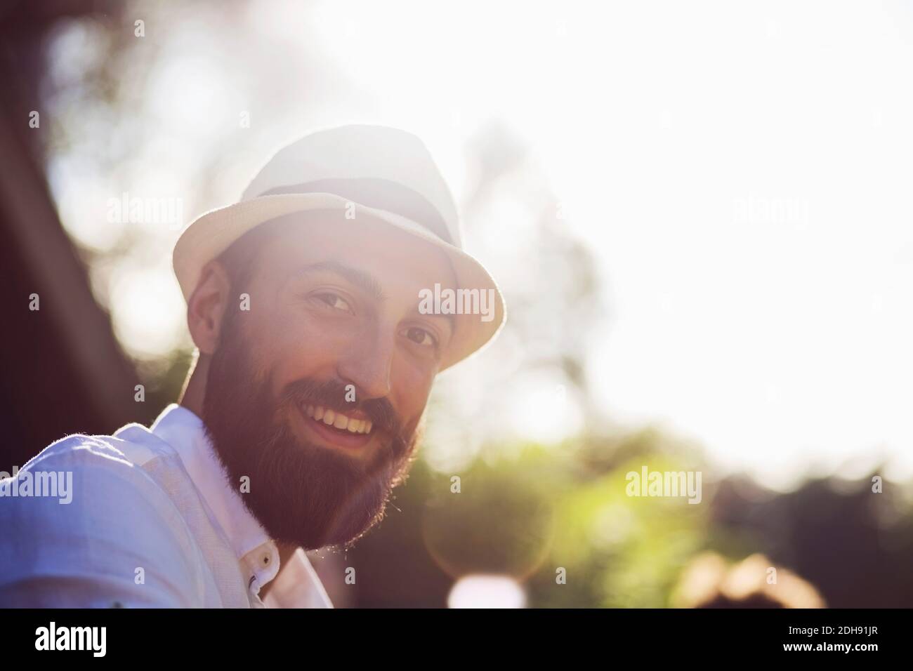 Low angle portrait of happy man wearing fedora on sunny day Stock Photo ...