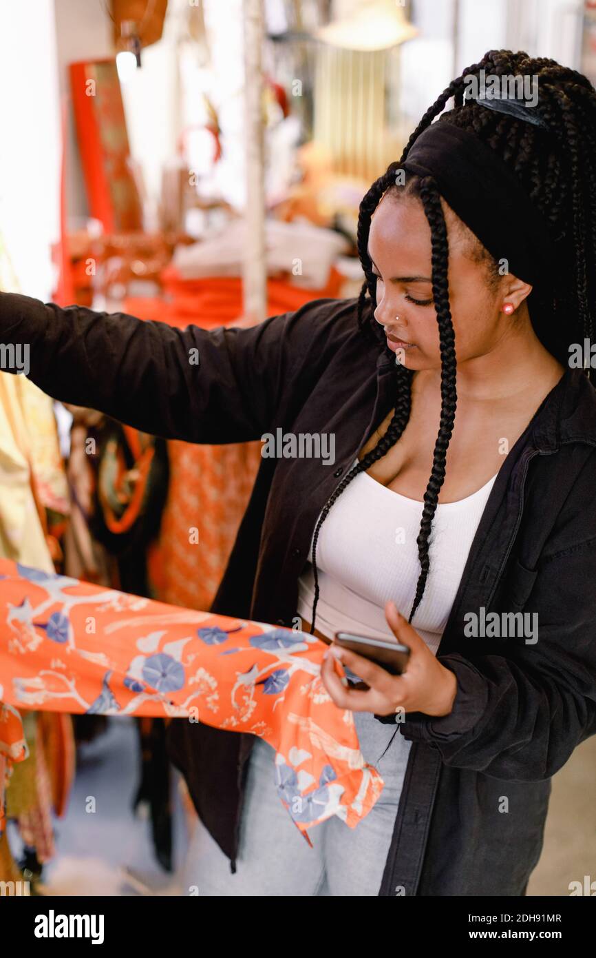 Young woman looking at clothes in fashion store Stock Photo - Alamy