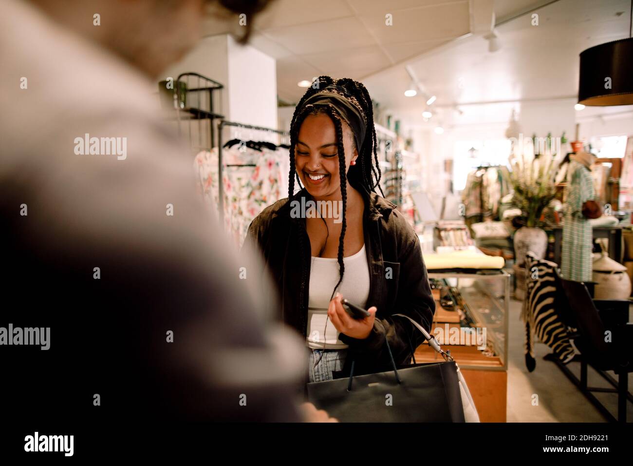 Happy female customer buying clothes from salesman at store Stock Photo ...