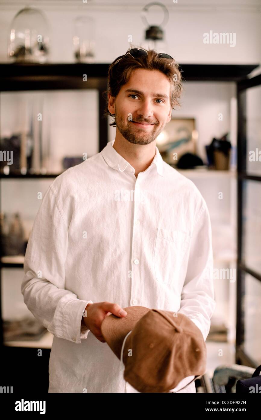 Portrait of male customer buying cap at retail store Stock Photo - Alamy