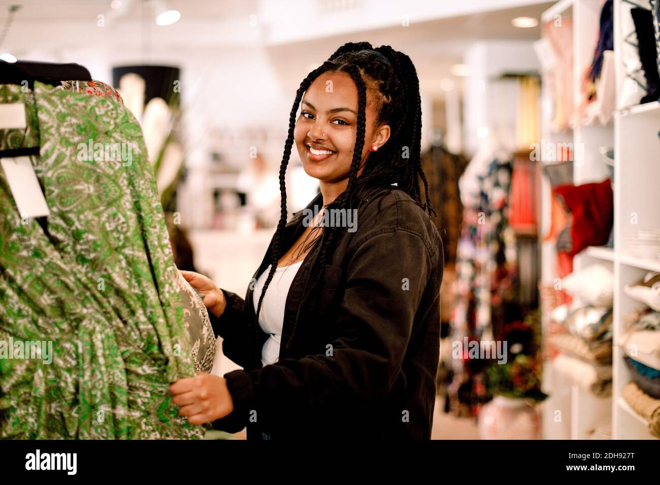 Portrait of smiling female customer standing at fashion store Stock ...