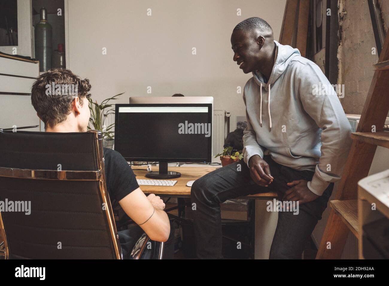 Computer programmers talking about coding at workplace Stock Photo - Alamy