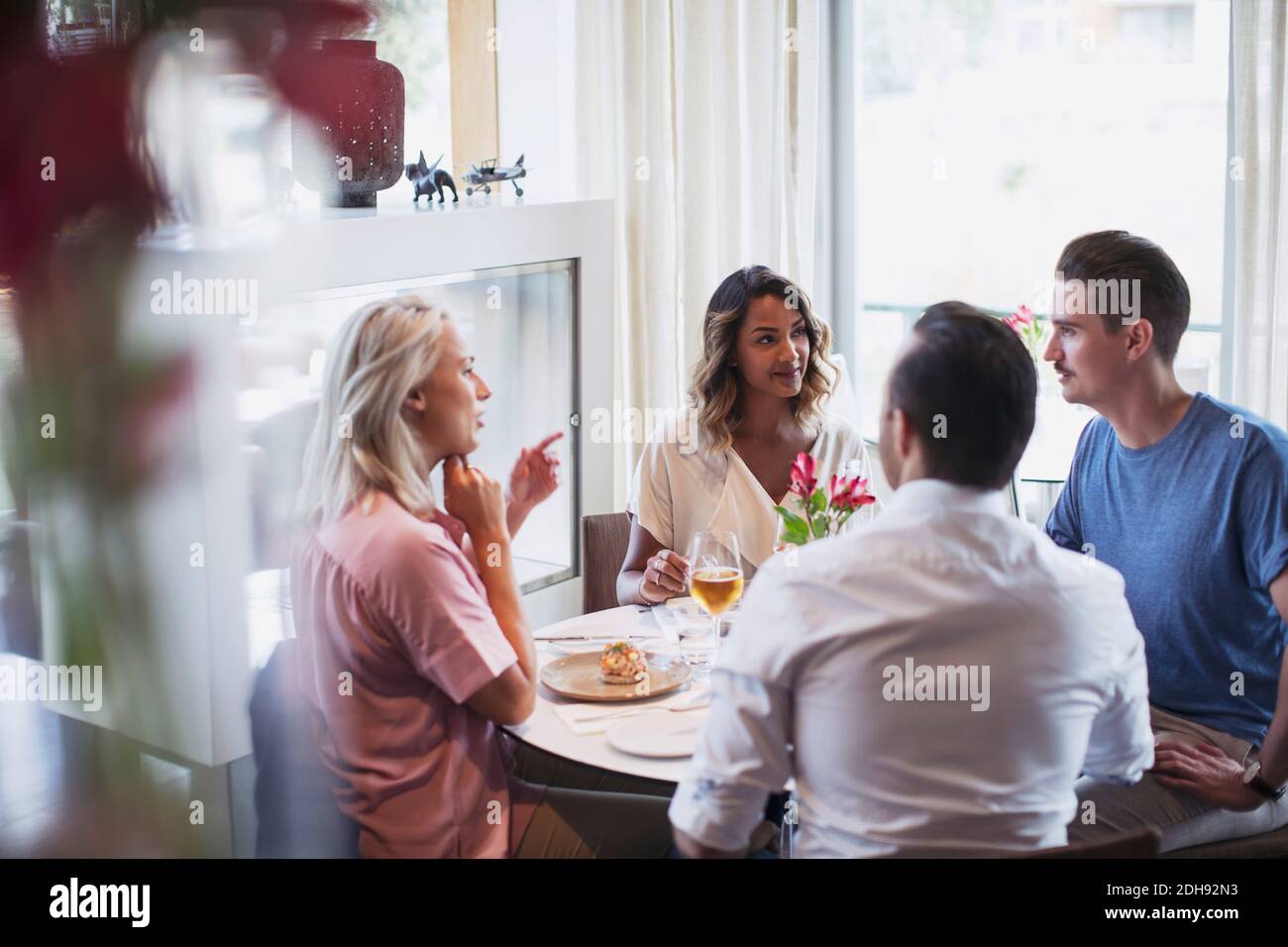 Business colleagues talking while eating lunch at restaurant during ...
