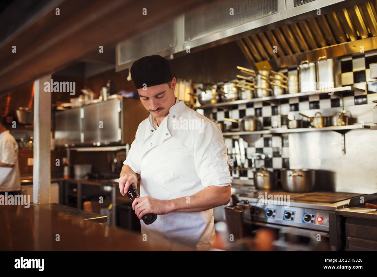 Waiter holding pepper mill at restaurant Stock Photo - Alamy