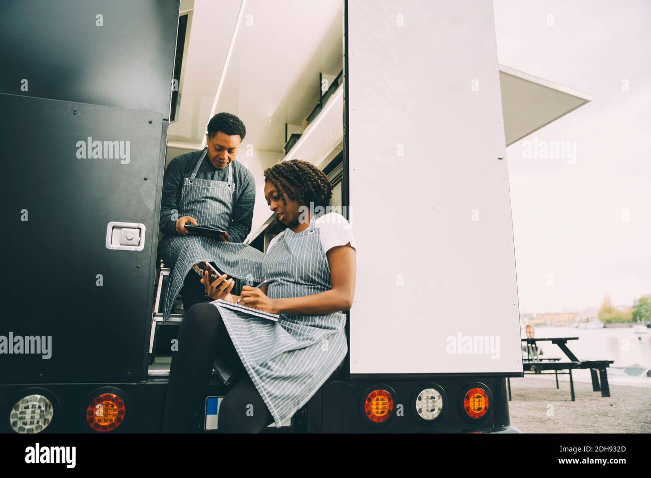 Female owner with assistant in food truck Stock Photo - Alamy