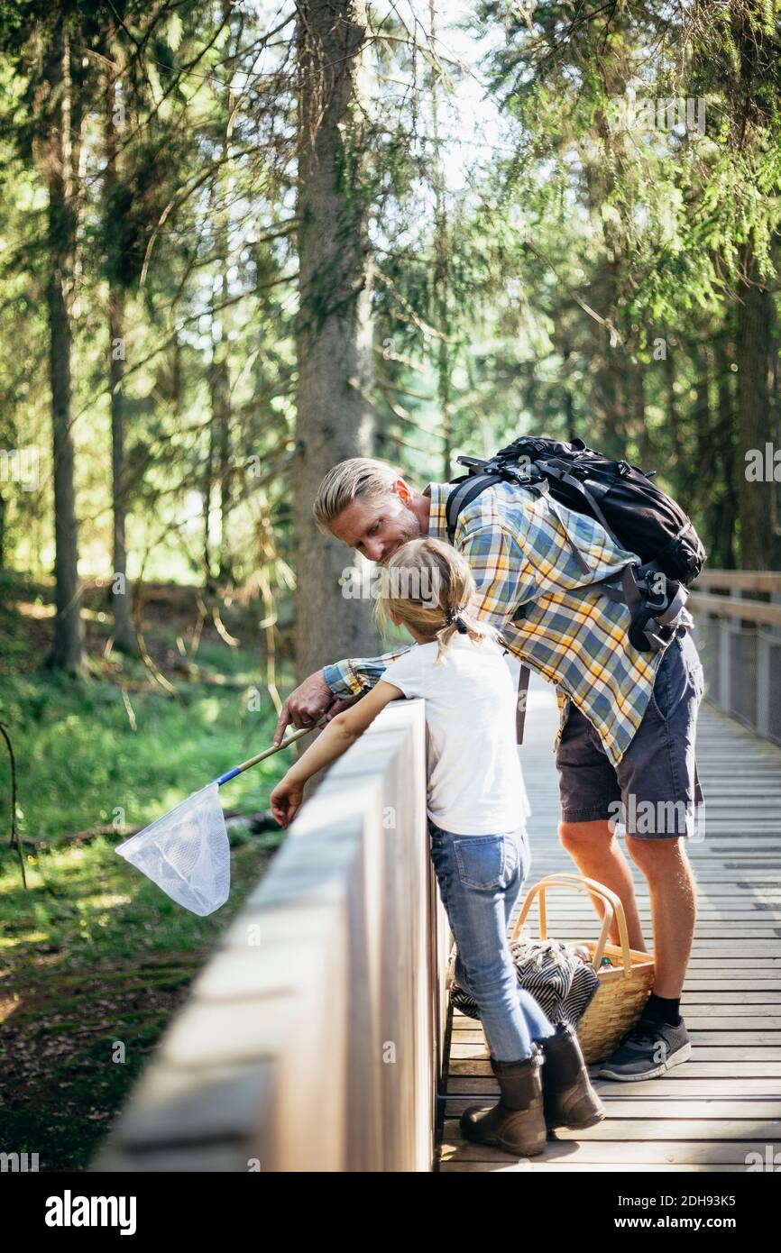 Father with backpack talking to daughter on footbridge in forest Stock ...