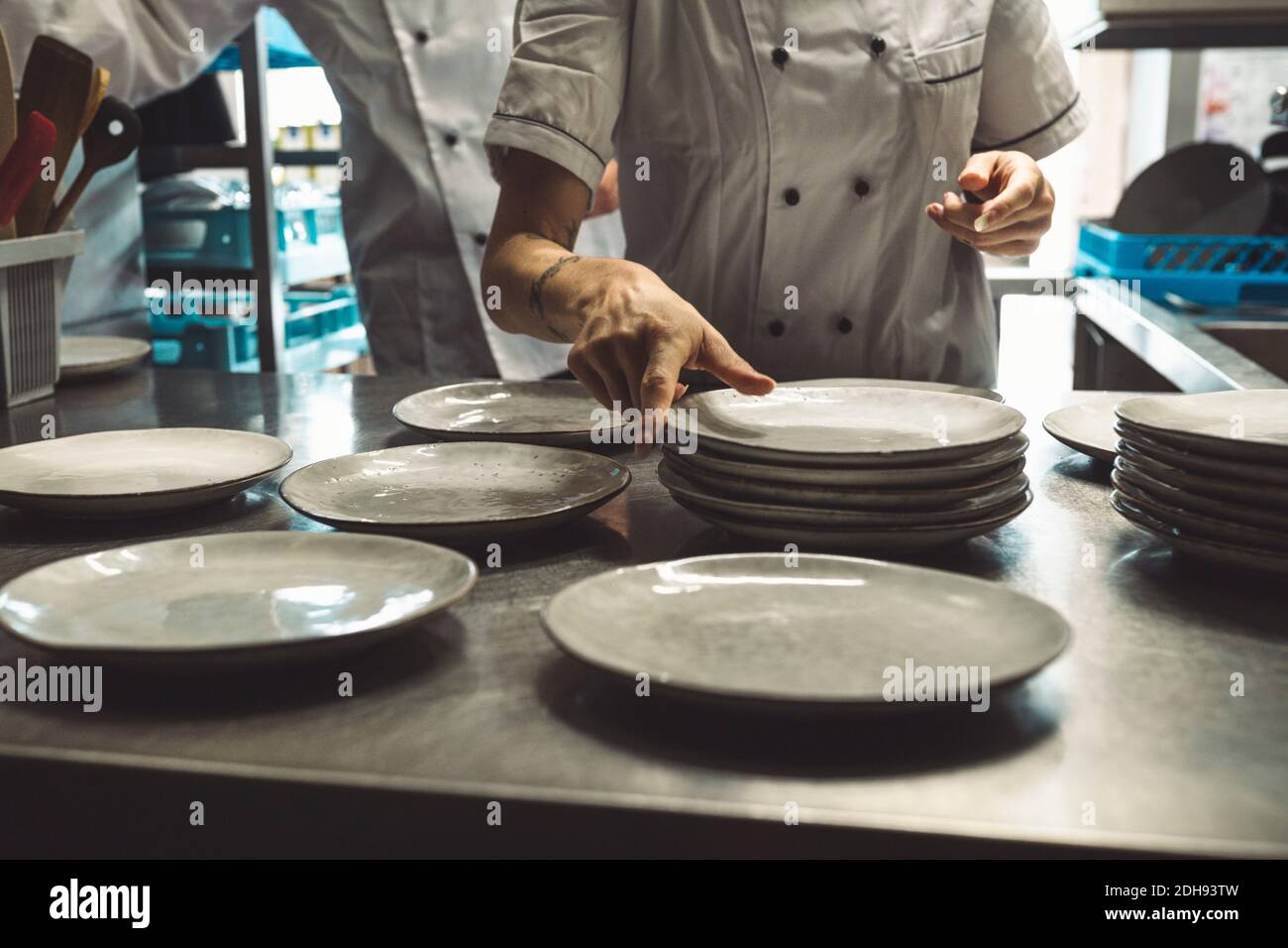 Midsection of chef arranging plates at kitchen counter Stock Photo - Alamy