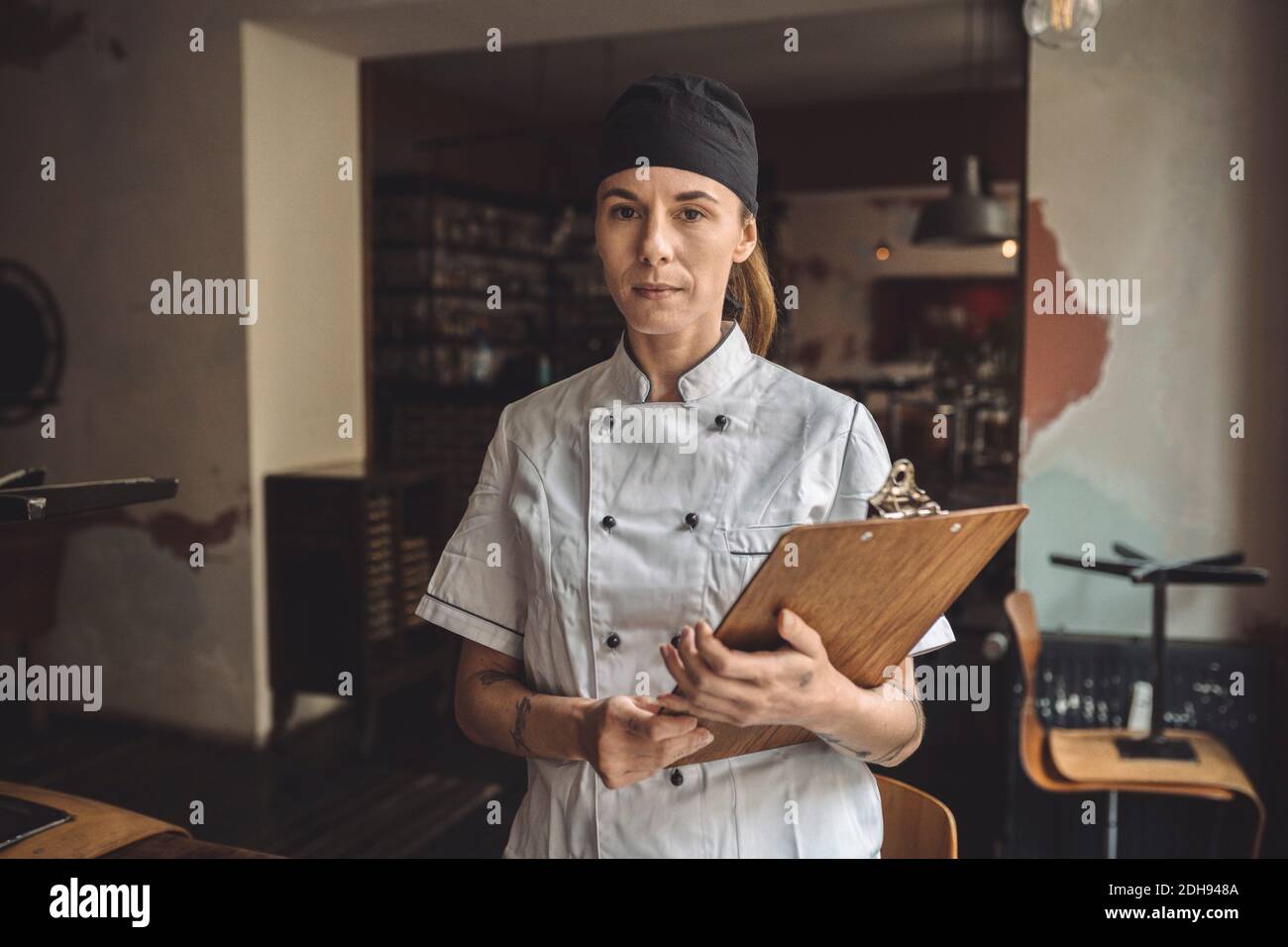 Portrait of chef with clipboard standing in restaurant Stock Photo - Alamy