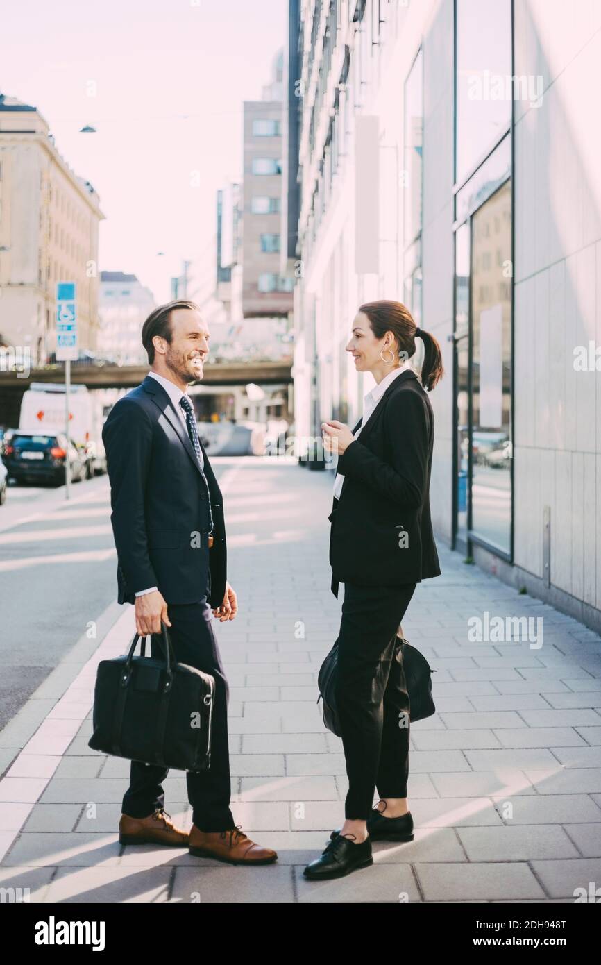 Side view of business people standing on sidewalk Stock Photo - Alamy