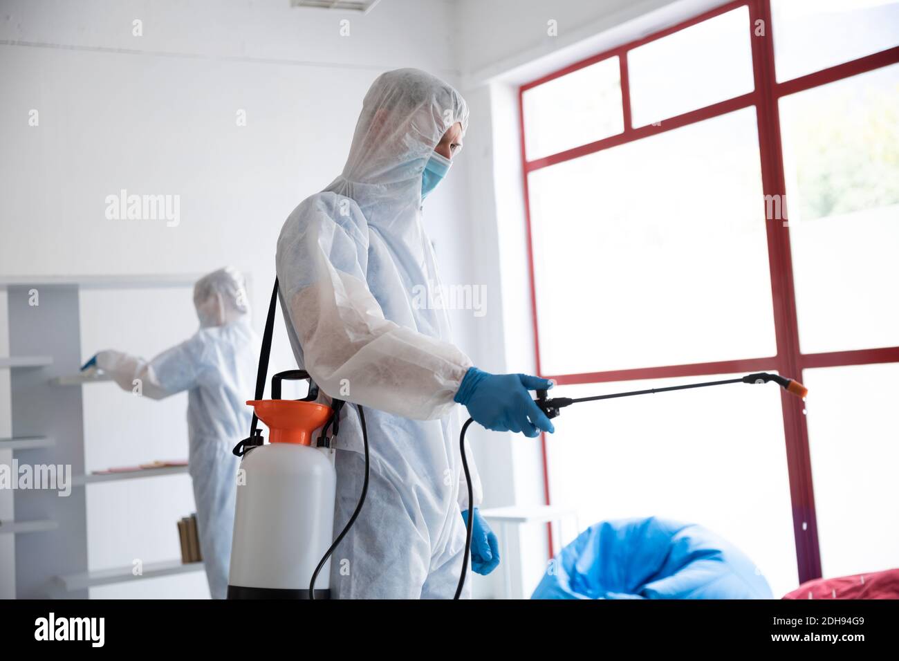Health worker wearing protective clothes cleaning using disinfectant ...