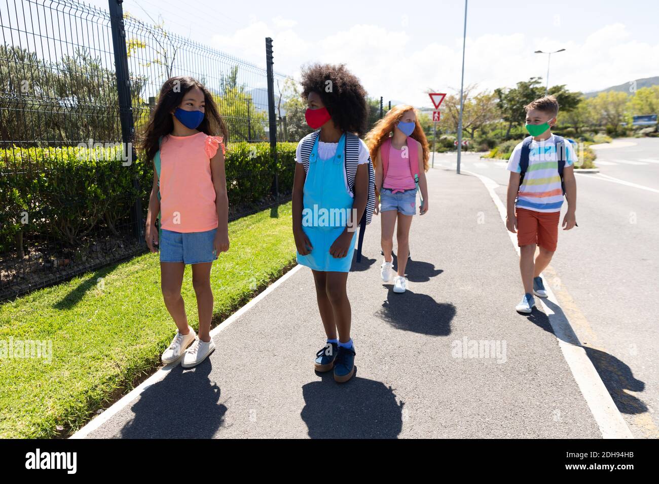 Group of kids wearing face masks walking on the road Stock Photo - Alamy