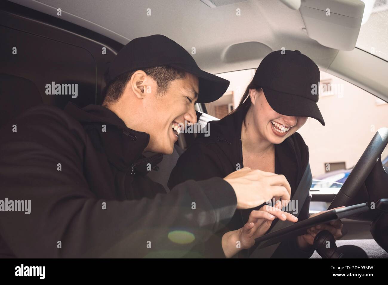 Smiling male and female drivers using digital tablet in truck Stock ...