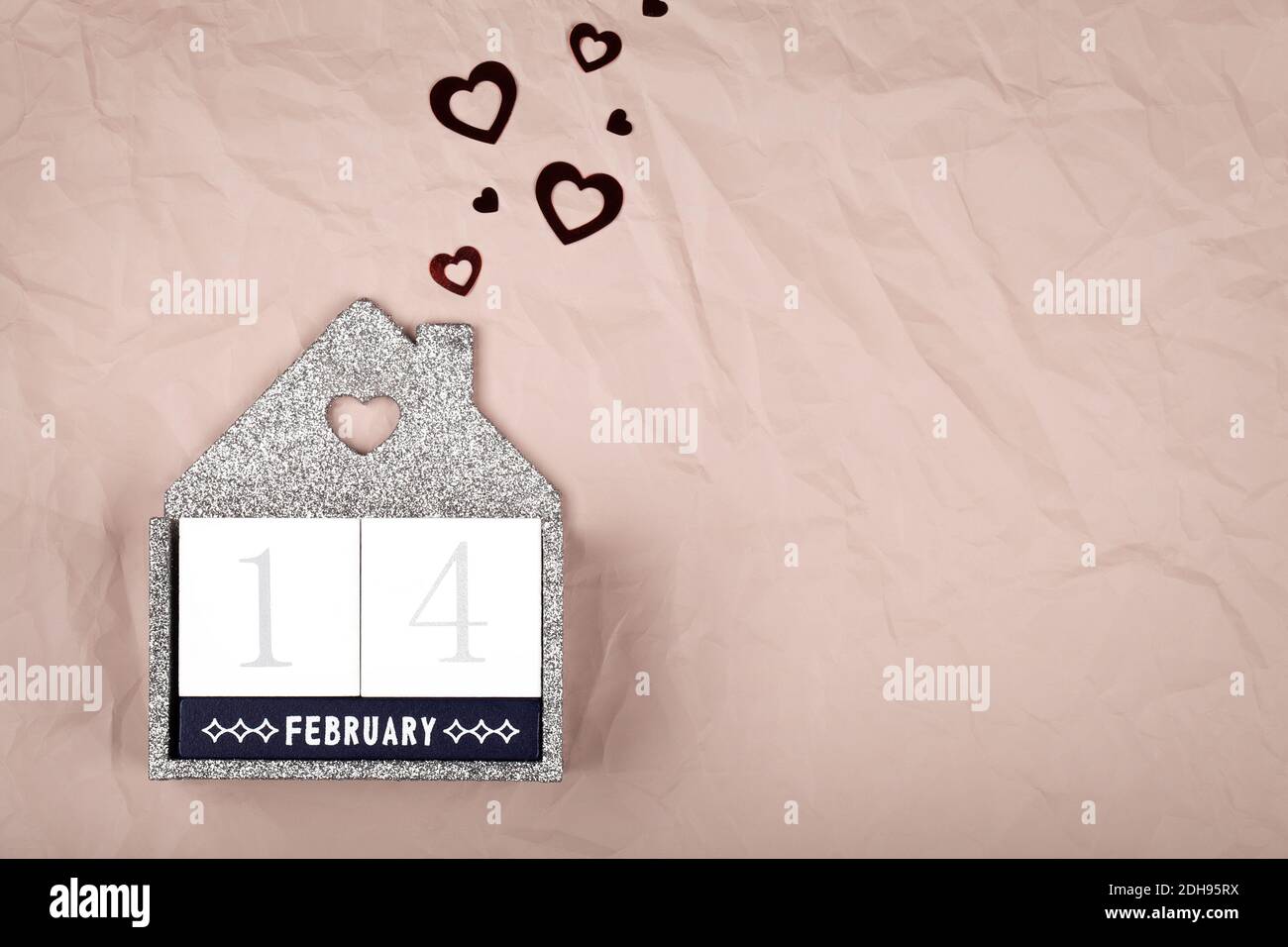silver block calendar February 14 on beige background with red confetti ...