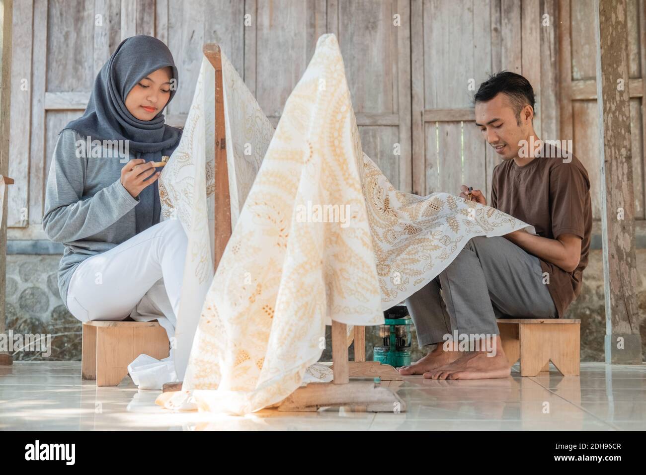 young woman and man drawing batik on a white cloth Stock Photo - Alamy