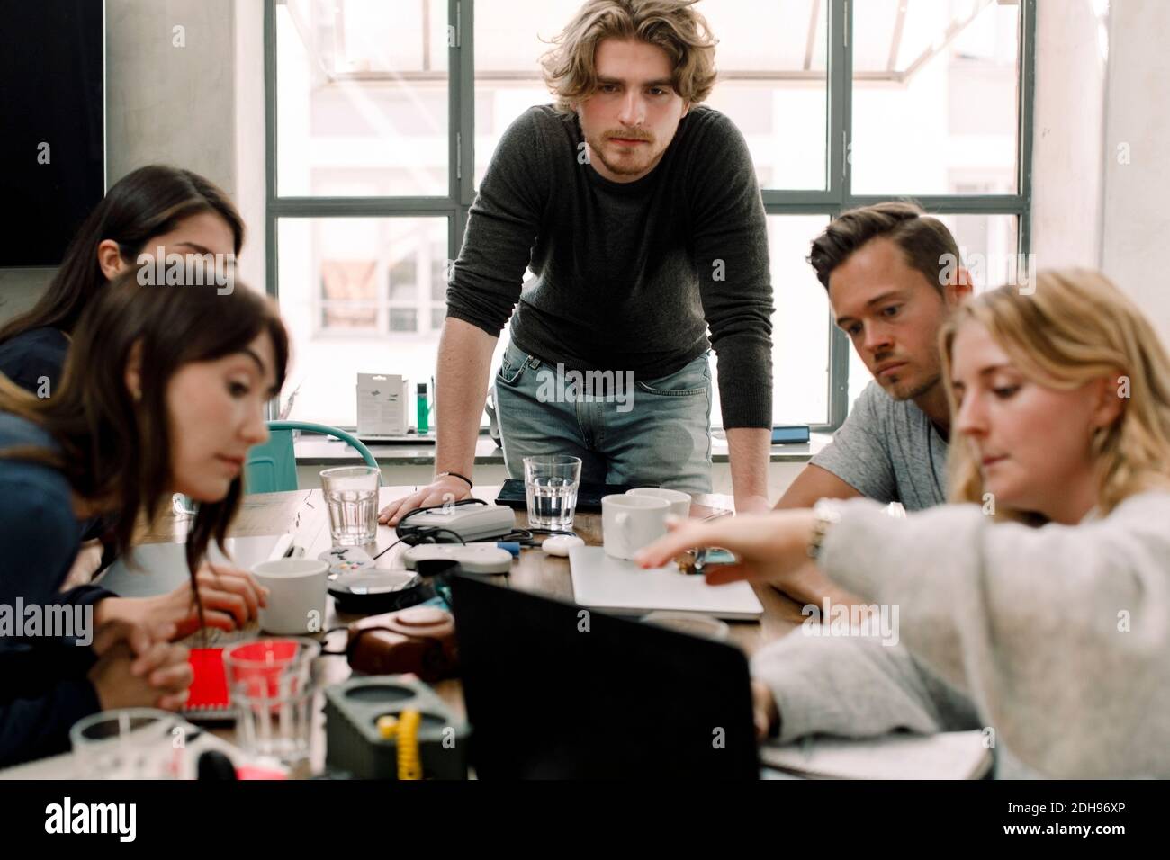 Businesswoman explaining while coworkers listening at workplace Stock ...