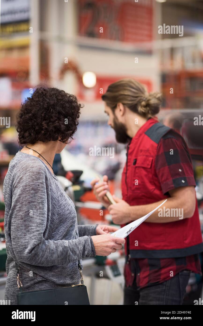Side view of salesman and customer standing in hardware store Stock ...