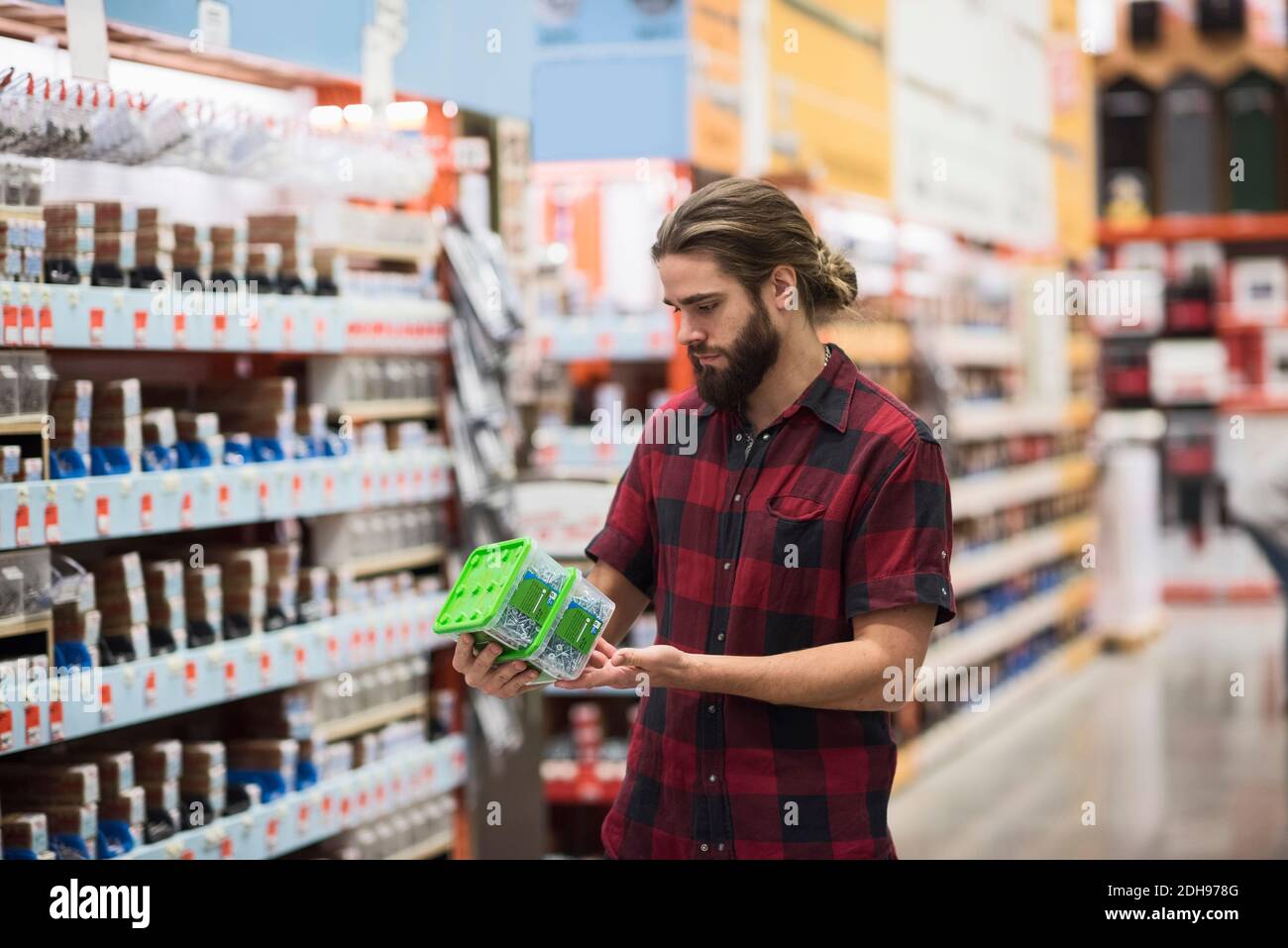 Male customer reading label on nail box in hardware store Stock Photo ...