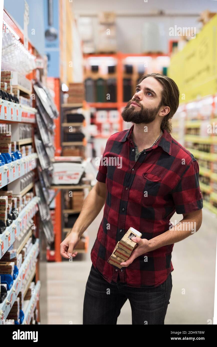 Male customer holding nail boxes from hardware store Stock Photo - Alamy