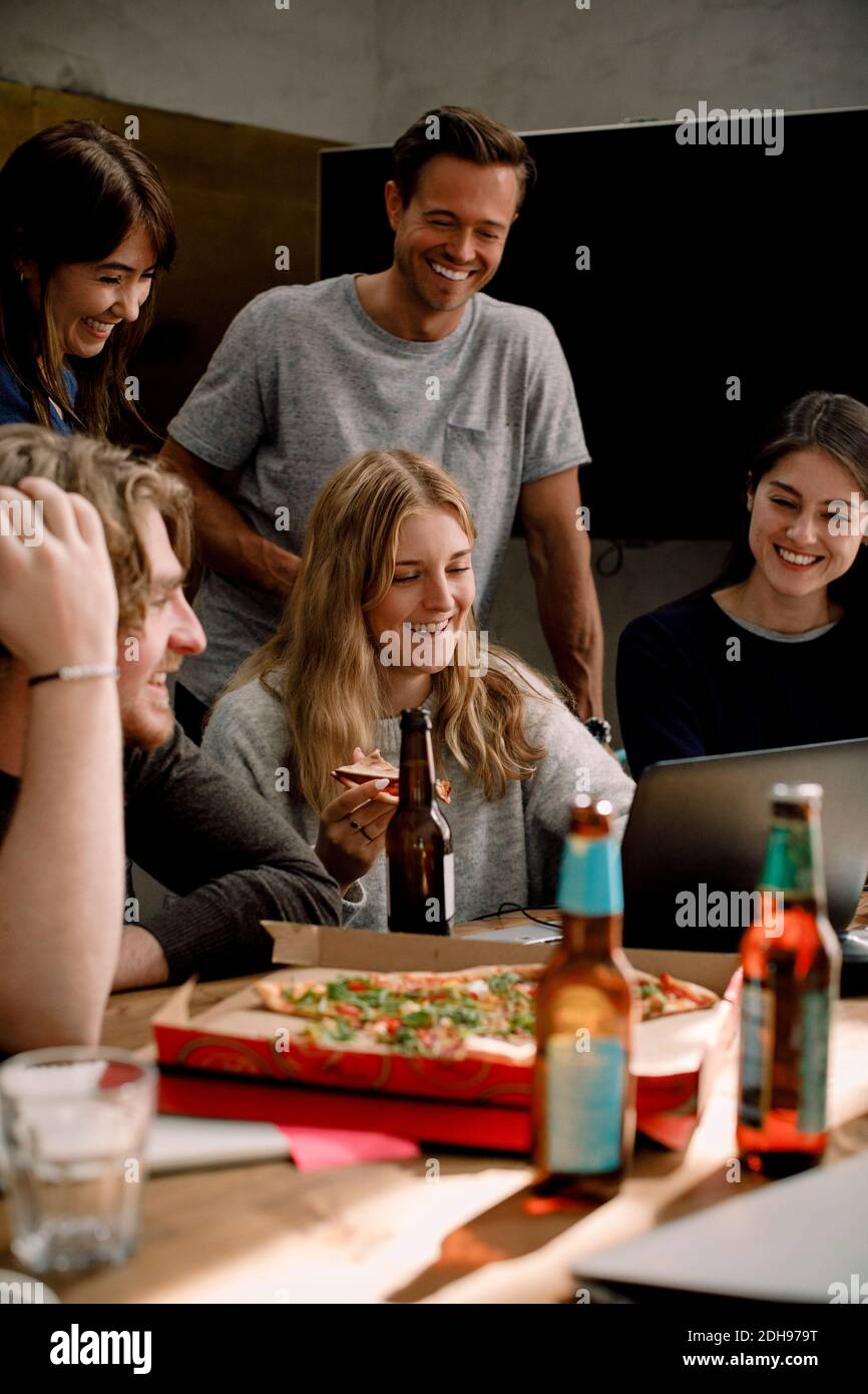 Businesswoman eating pizza in office hi-res stock photography and ...
