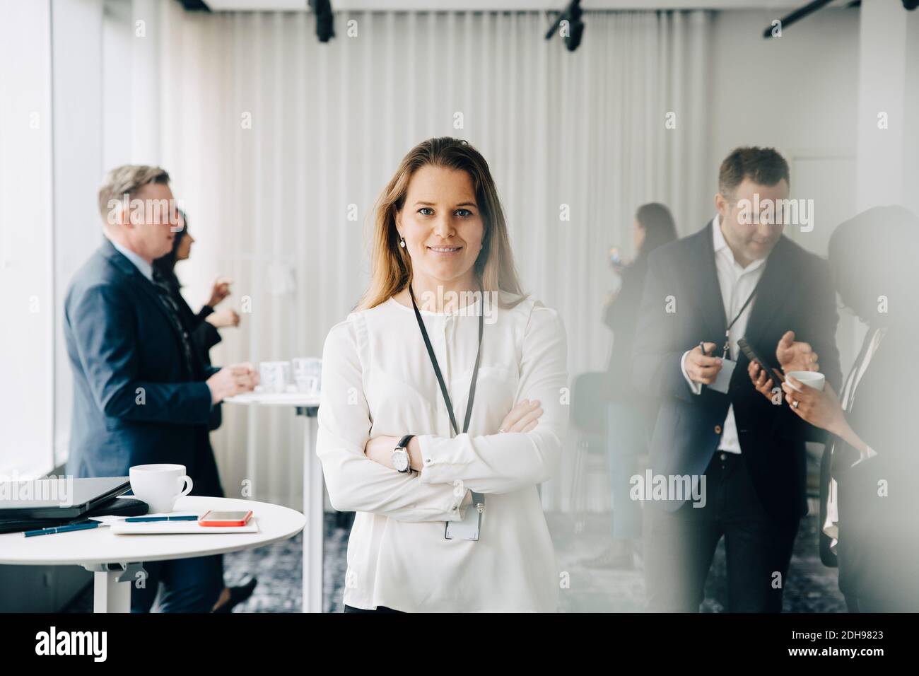 Hispanic businesswoman standing arms hi-res stock photography and ...