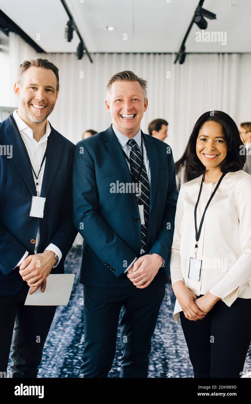 Portrait of happy business professionals standing at workplace Stock ...
