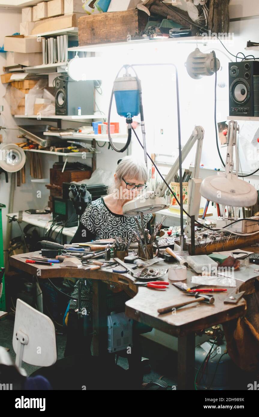 Senior working making jewelry at workbench in workshop Stock Photo - Alamy