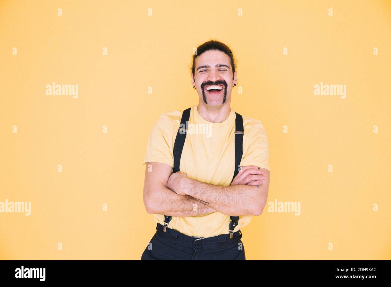 Happy man standing against yellow background Stock Photo - Alamy
