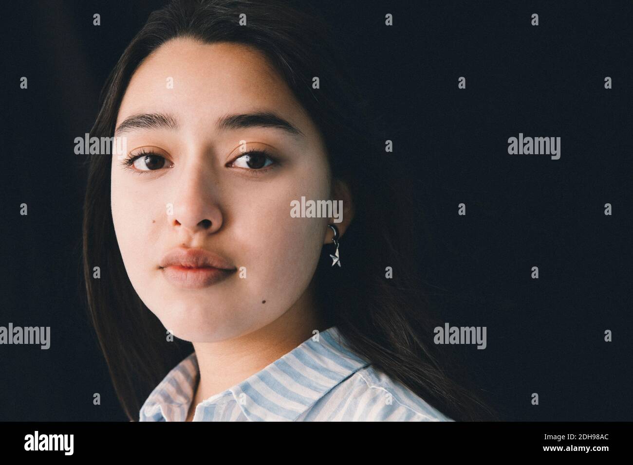 Portrait of teenage girl against black background Stock Photo - Alamy