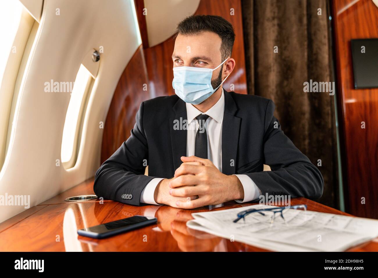 Handsome businessman wearing elegant suit flying on exclusive private ...