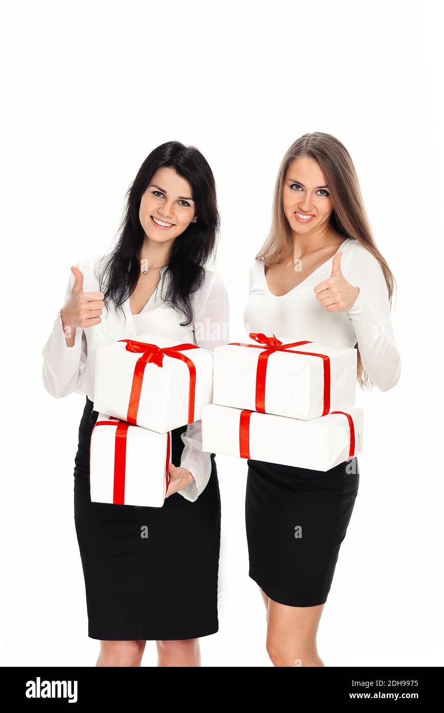 two young women with gift boxes showing thumbs up Stock Photo - Alamy