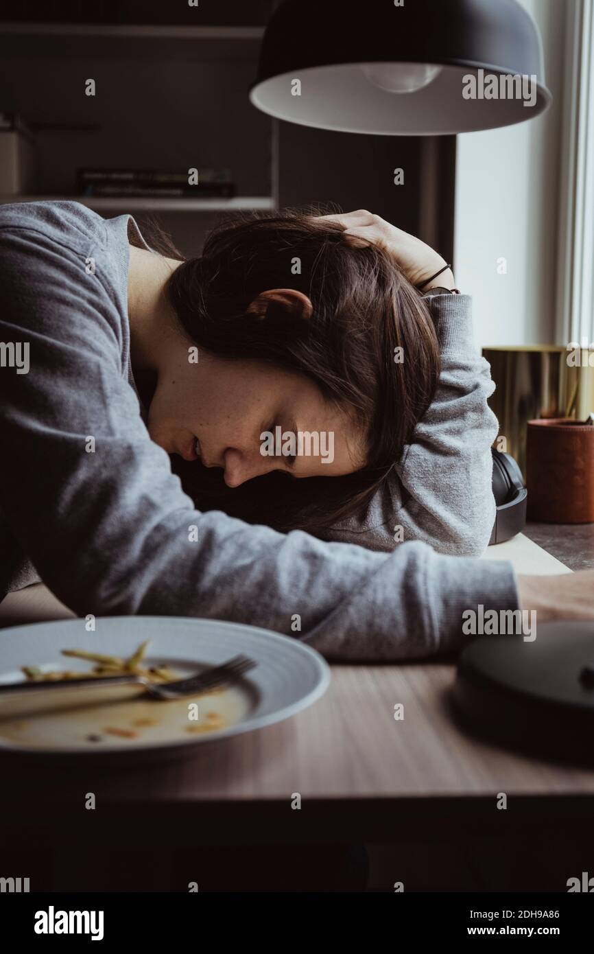 Side view of sad woman at table Stock Photo - Alamy