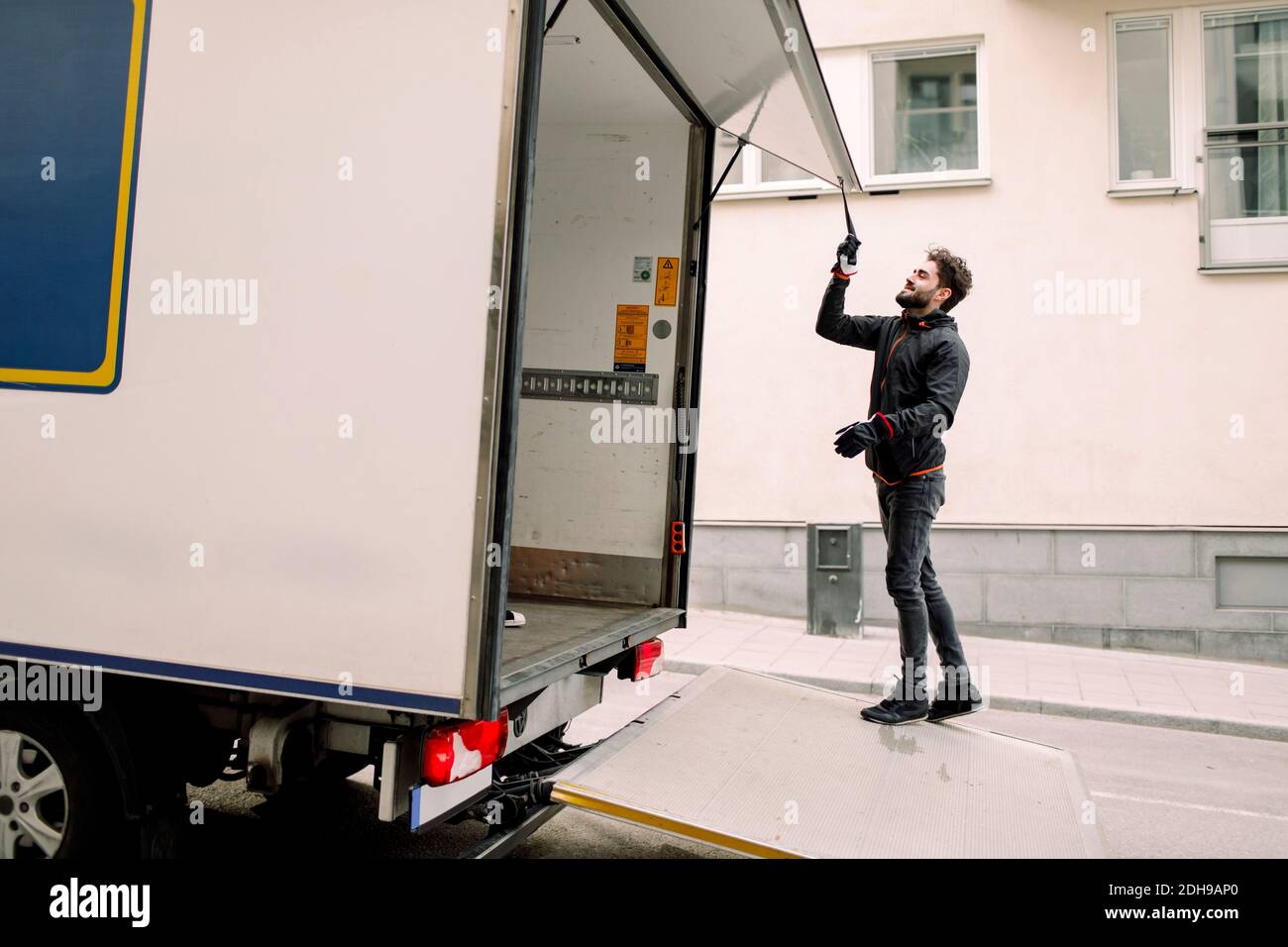 Young delivery man with truck on street in city Stock Photo - Alamy
