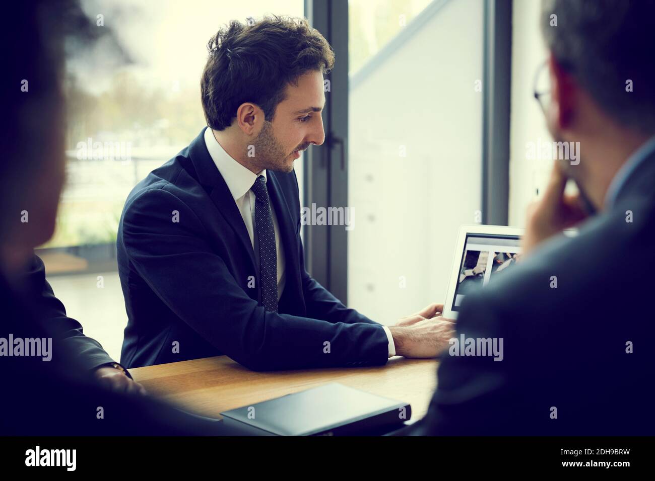 Young male financial advisor explaining strategy with laptop during ...