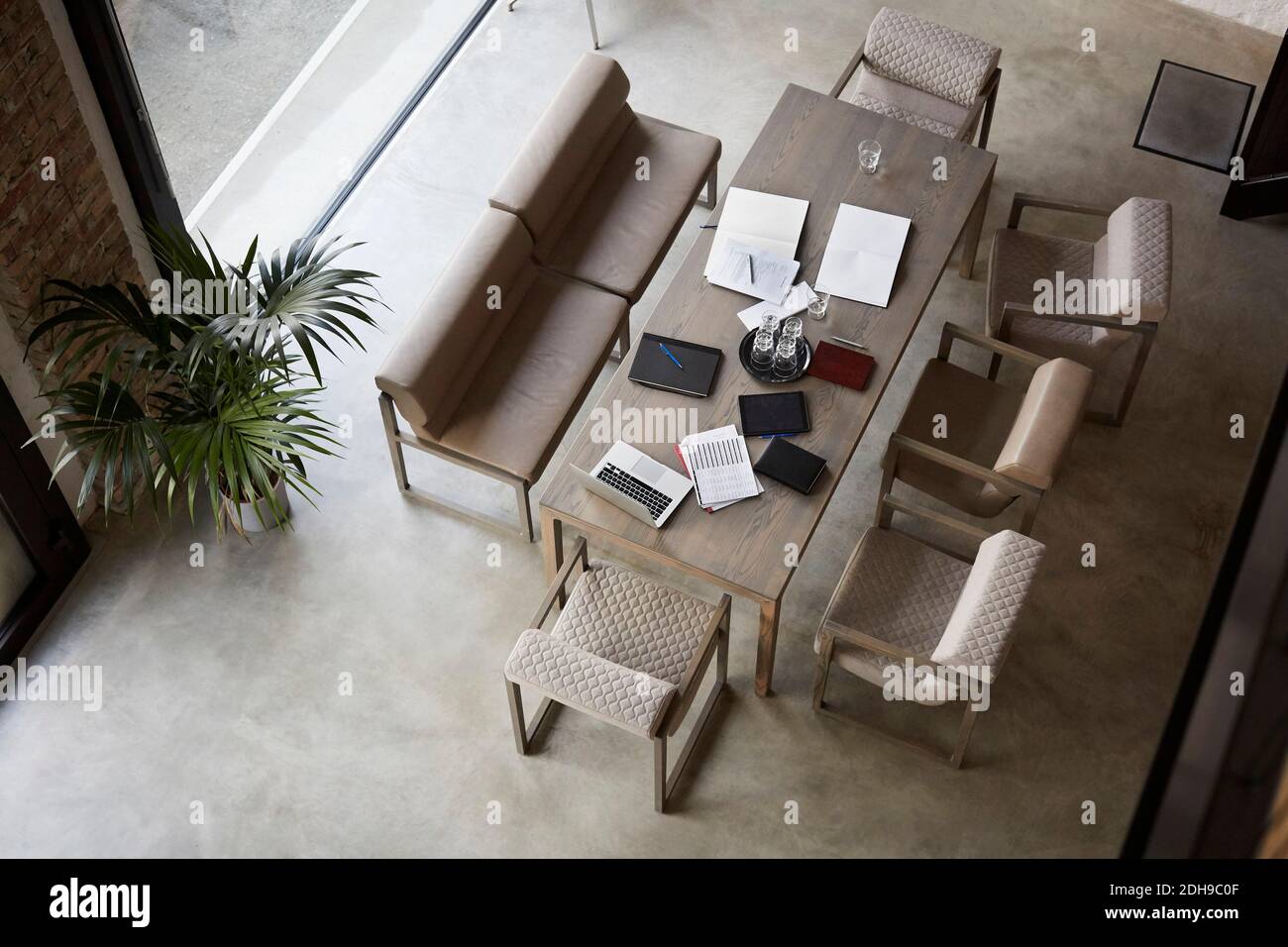 High angle view of documents and laptop on desk amidst chairs at law ...