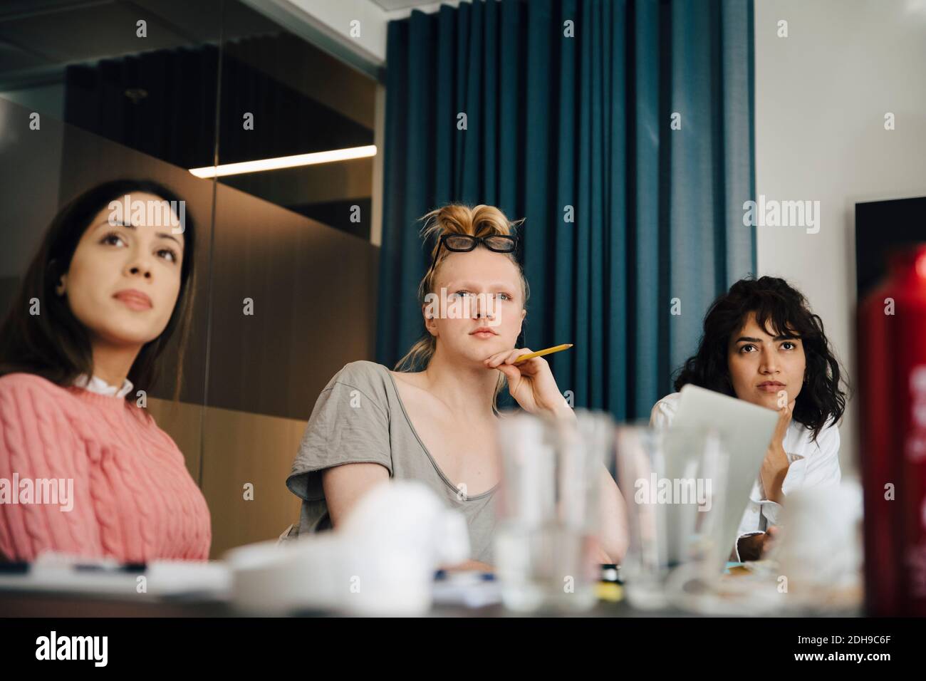 Transgender professional sitting amidst businesswomen in board room ...
