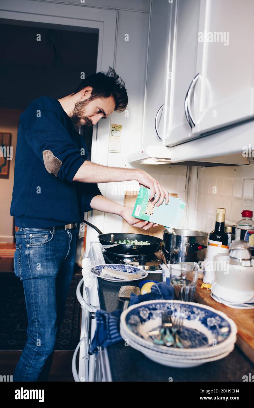Side view of man cooking in kitchen at home Stock Photo - Alamy